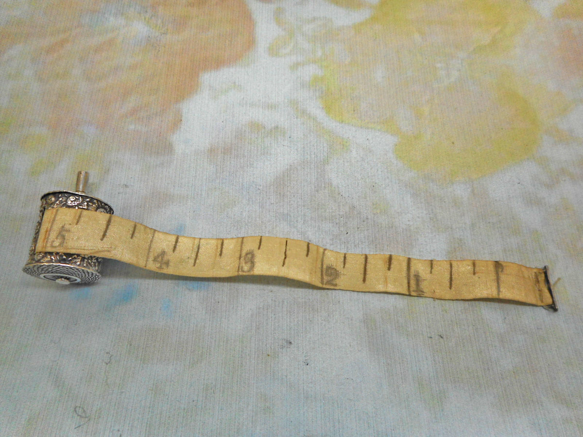 An embossed silver tape measure. c1830 – Curio Cabinet Antiques